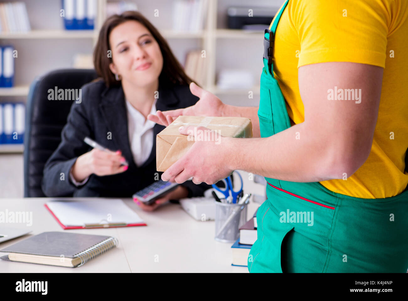 Postman delivering parcel to the office Stock Photo - Alamy