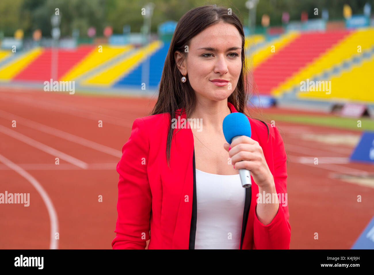 Pretty journalist is reporting from the stadium for TV show Stock Photo ...
