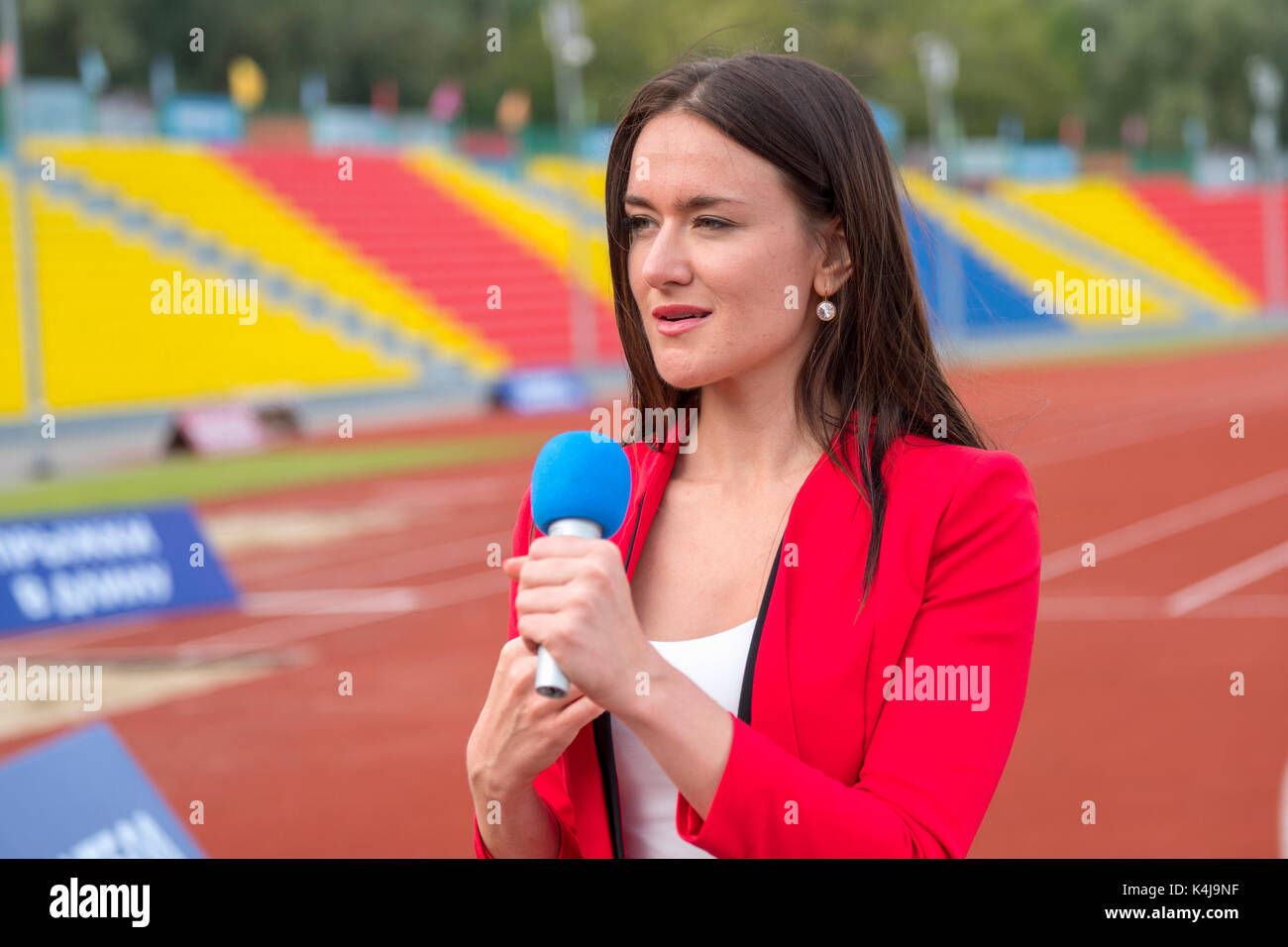 Pretty journalist is reporting from the stadium for TV show Stock Photo ...