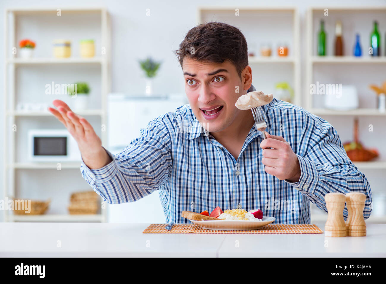 Man eating tasteless food at home for lunch Stock Photo - Alamy