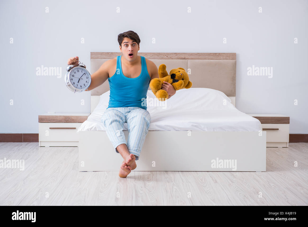 Young man waking up in bed Stock Photo - Alamy