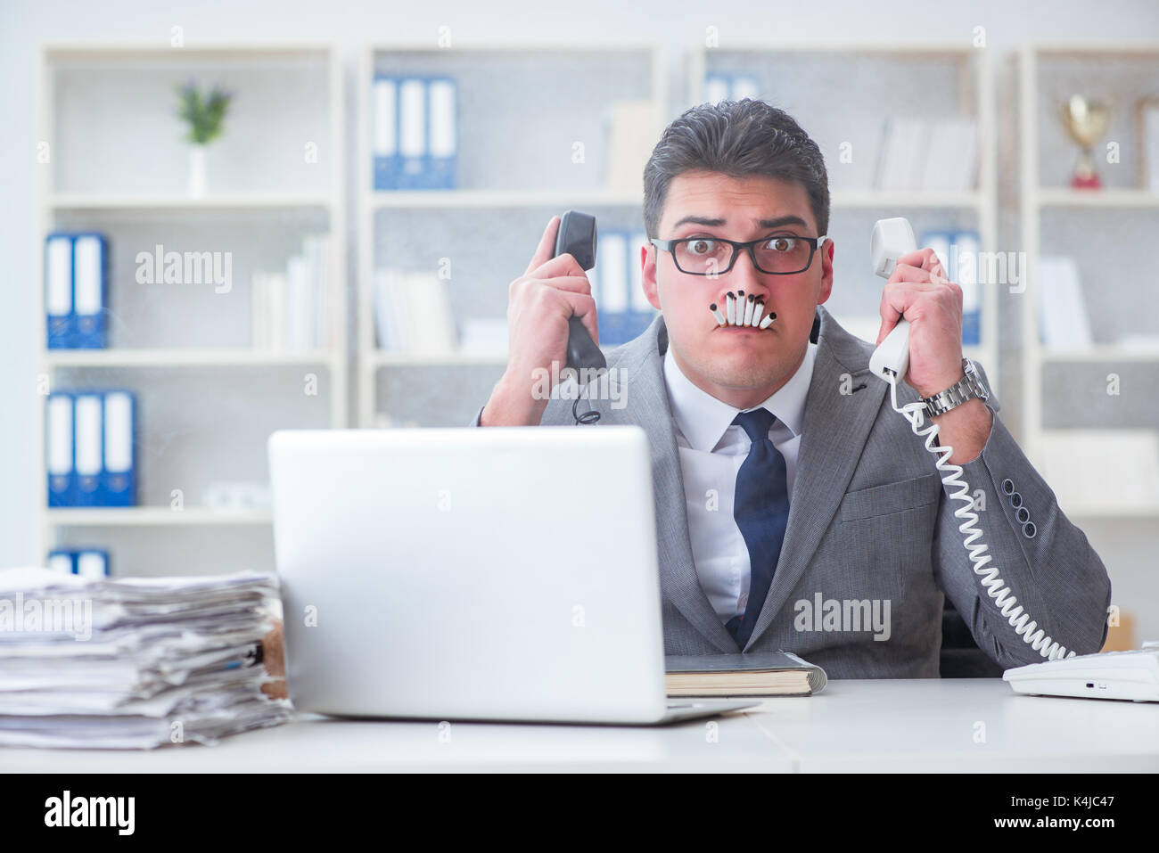 Businessman smoking in office at work Stock Photo - Alamy