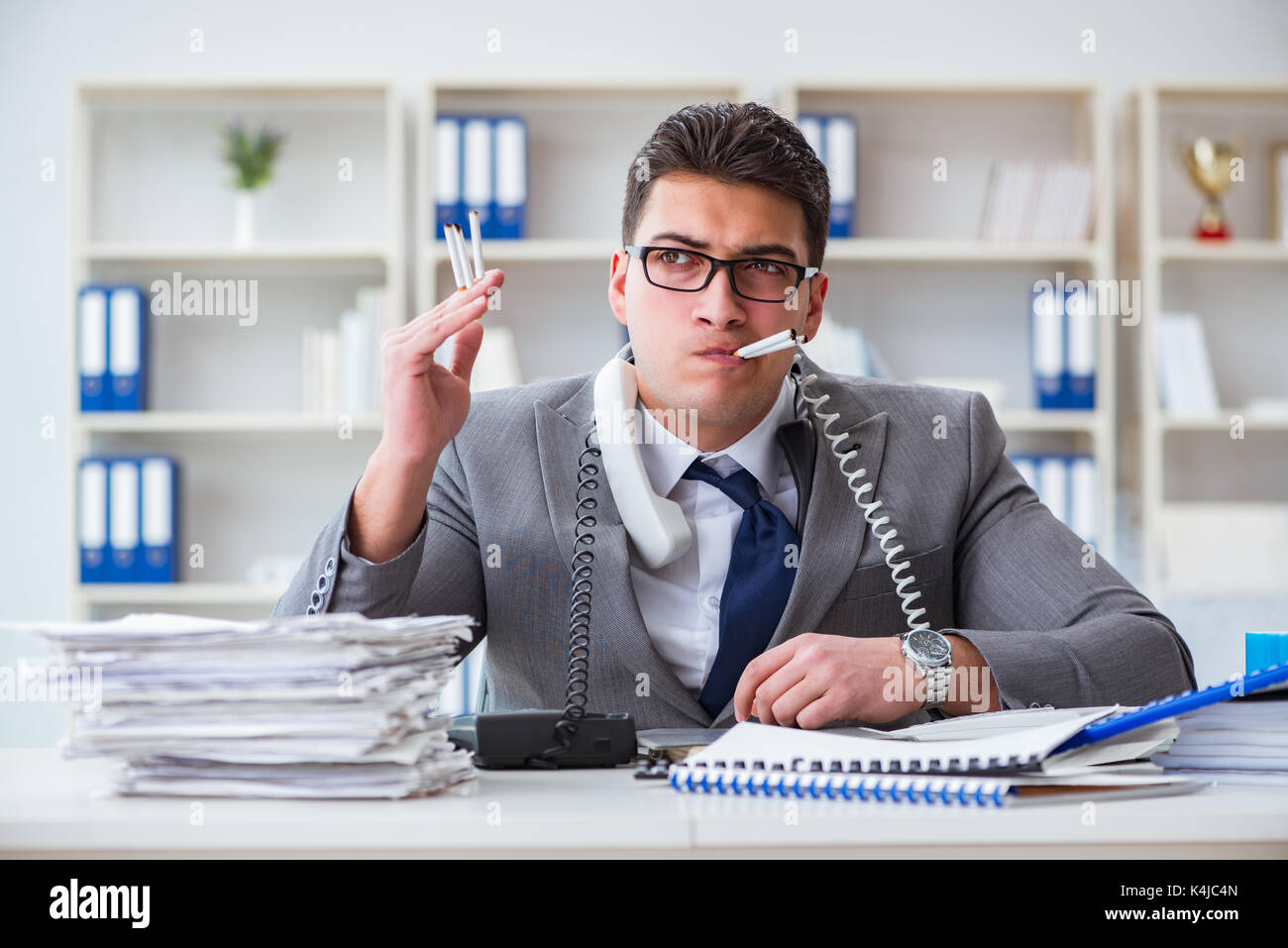 Businessman smoking in office at work Stock Photo - Alamy