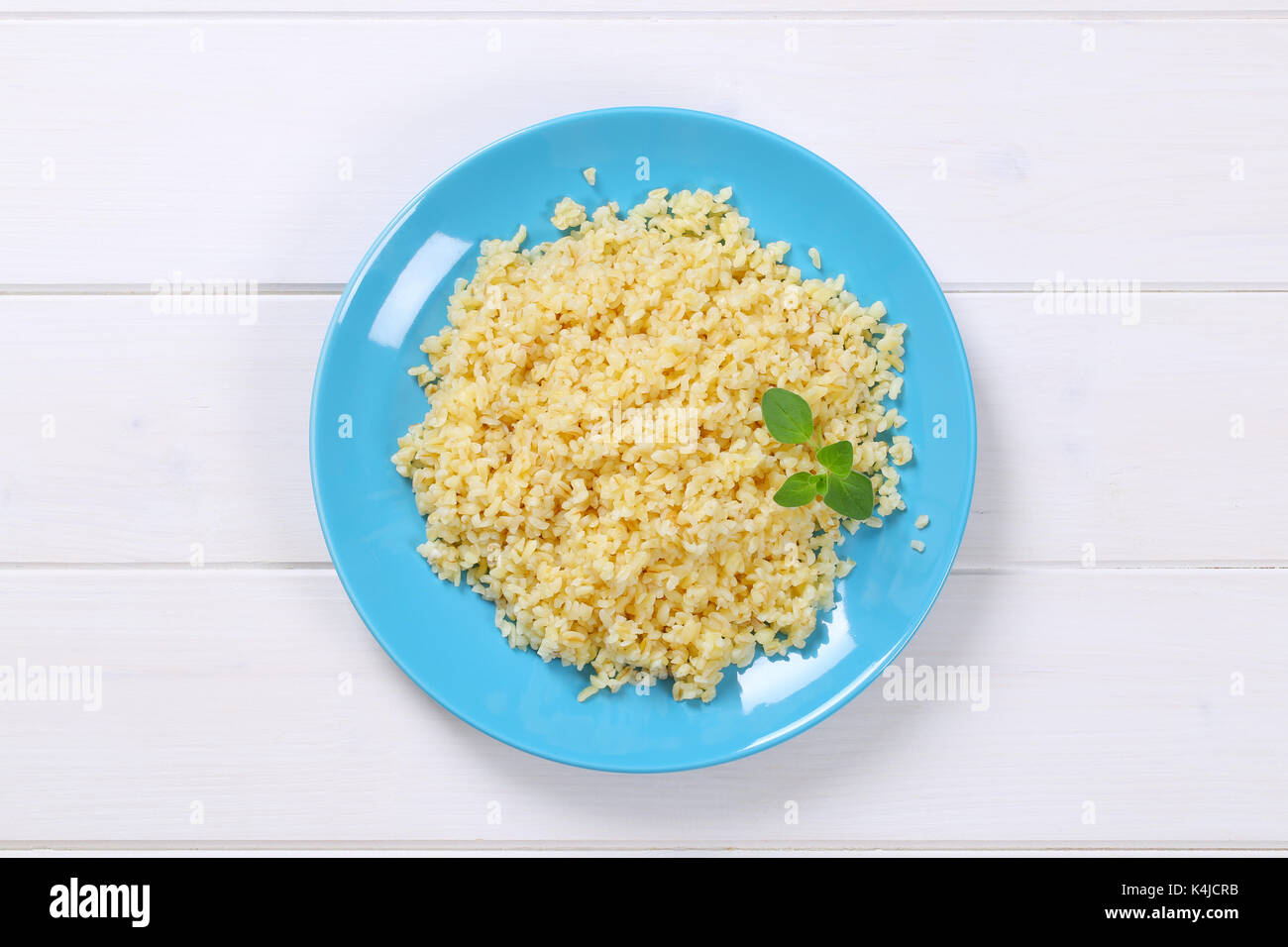Cooked whole groats on blue plate Stock Photo - Alamy