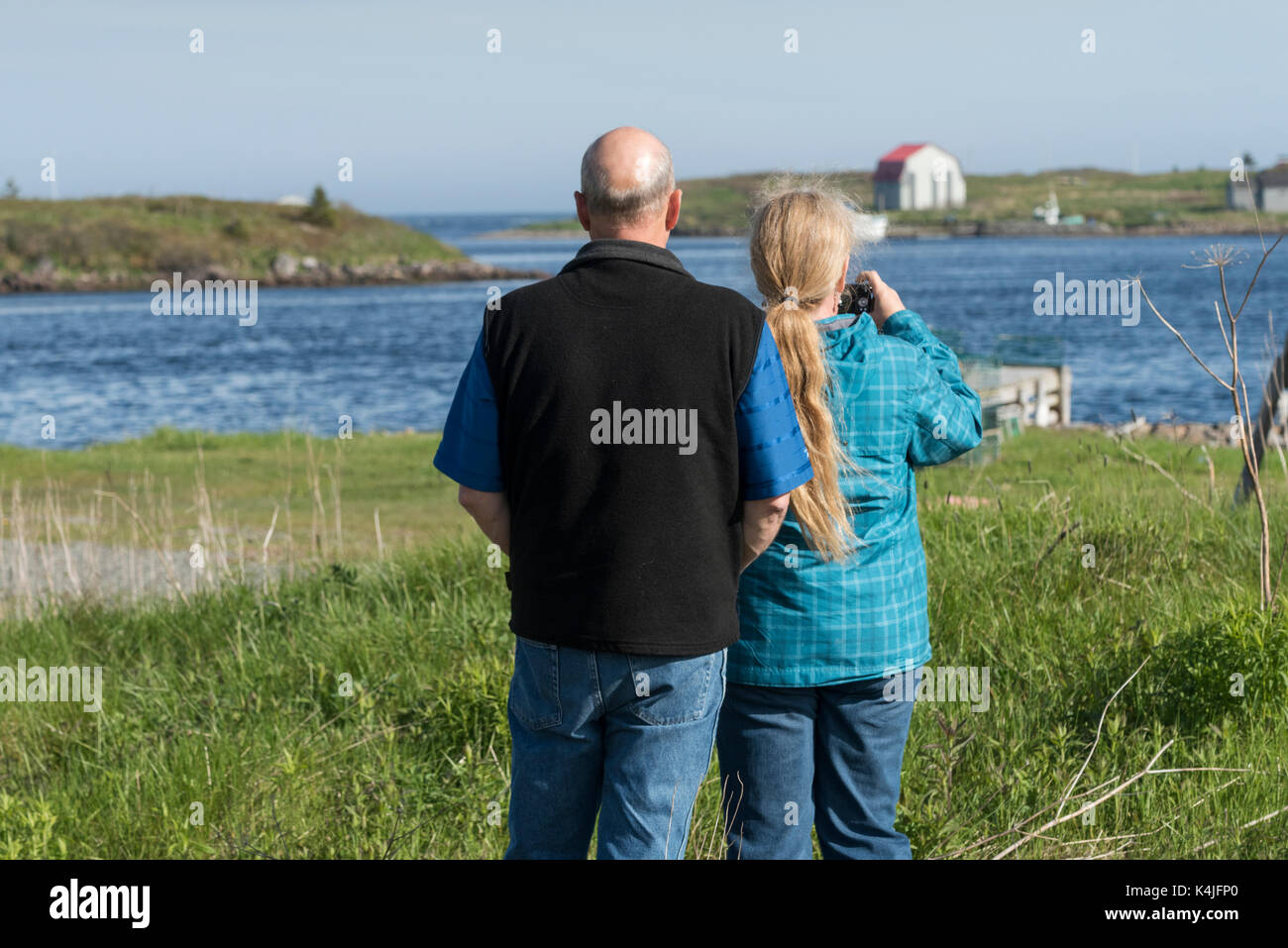 Rear view of couple taking picture with camera at riverbank, Cape ...