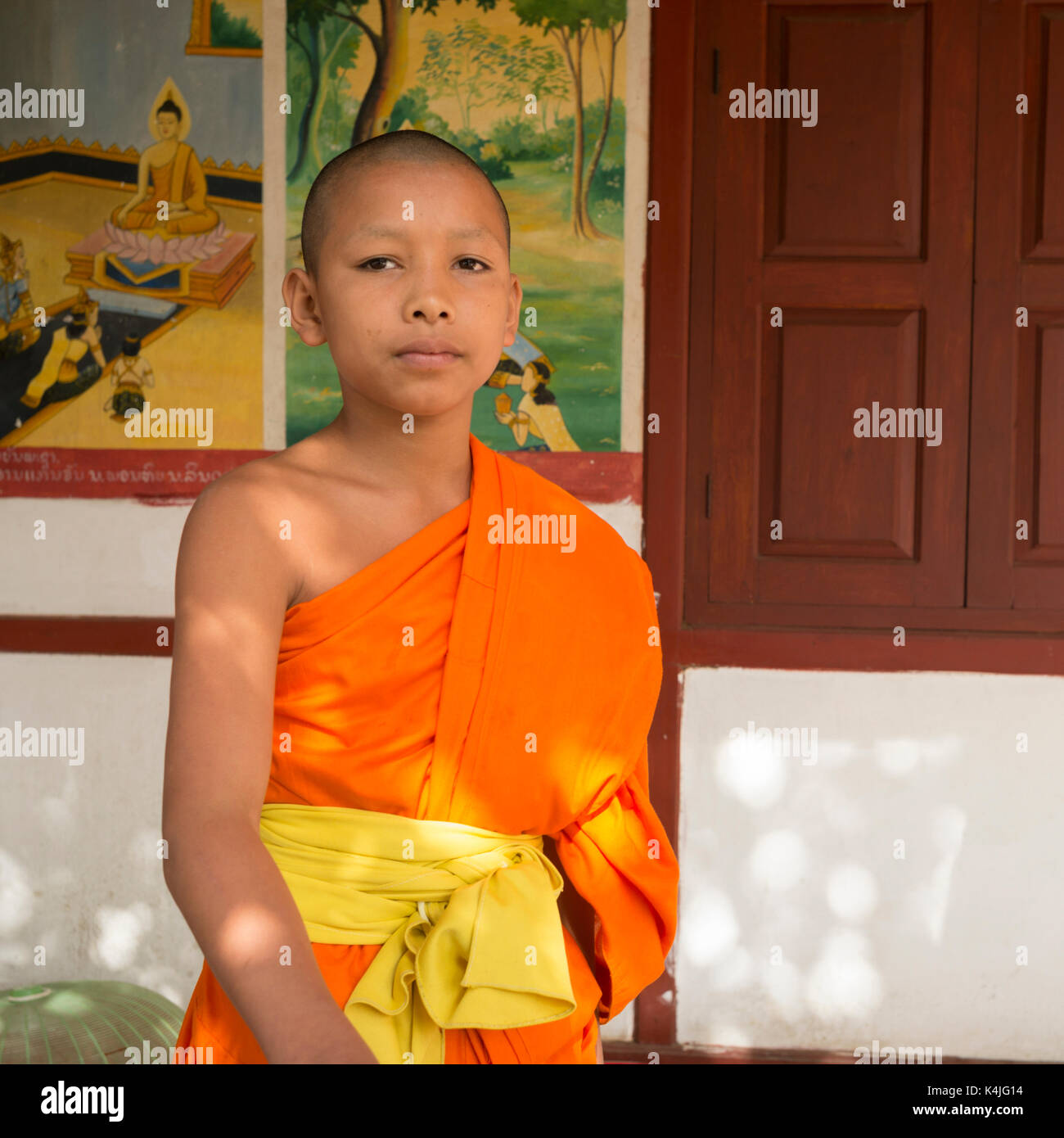 Portrait of boy monk standing outside temple, Luang Prabang, Laos Stock ...