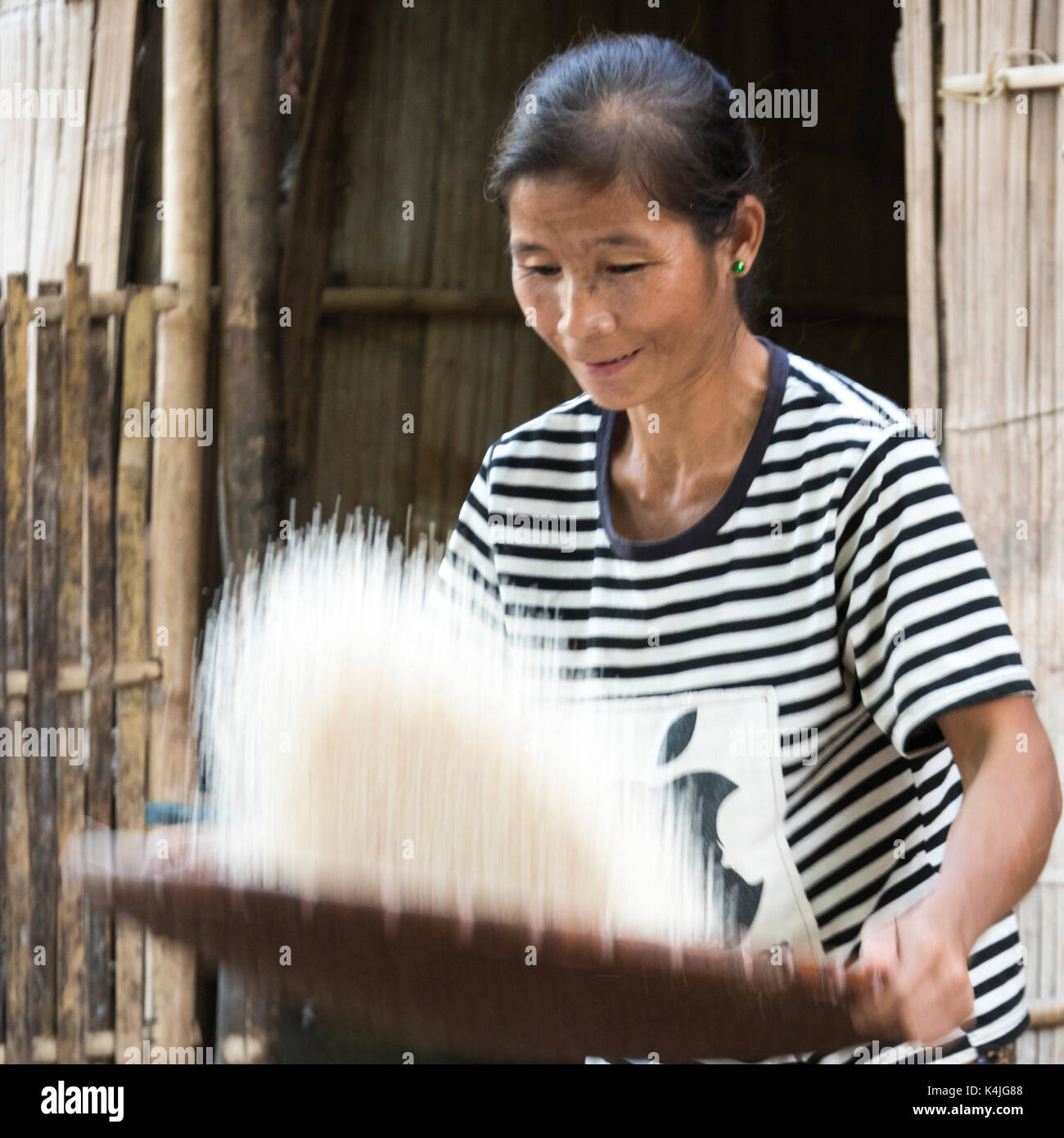 Woman tossing rice in basket, Ban Gnoyhai, Luang Prabang, Laos Stock ...