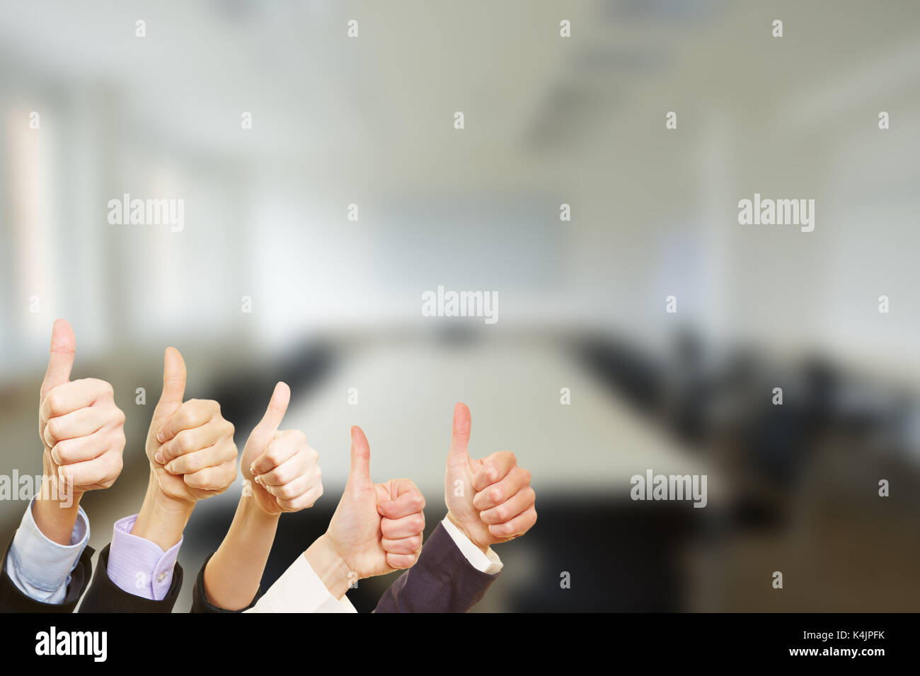 Business group holds thumbs up at work for motivation Stock Photo - Alamy