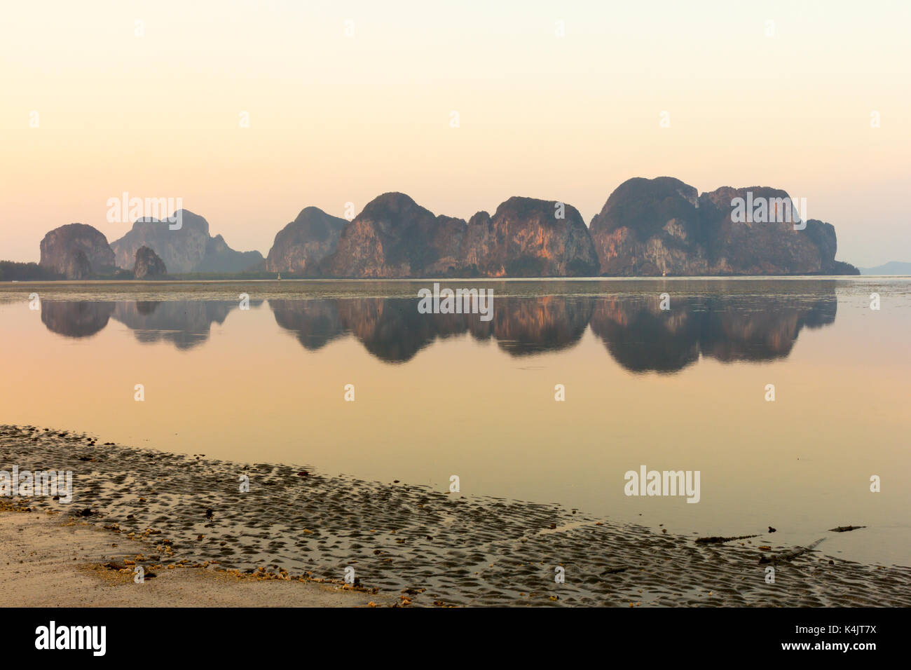 Sunrise and reflections of limestone cliffs, Hua Hin beach, Trang ...