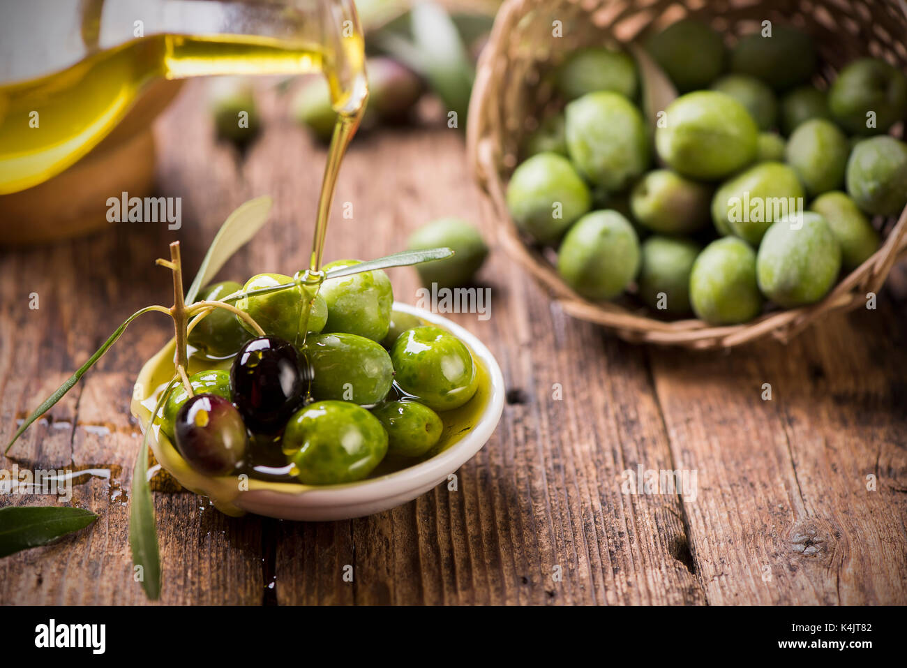 Bottle pouring virgin olive oil in a bowl close up Stock Photo - Alamy