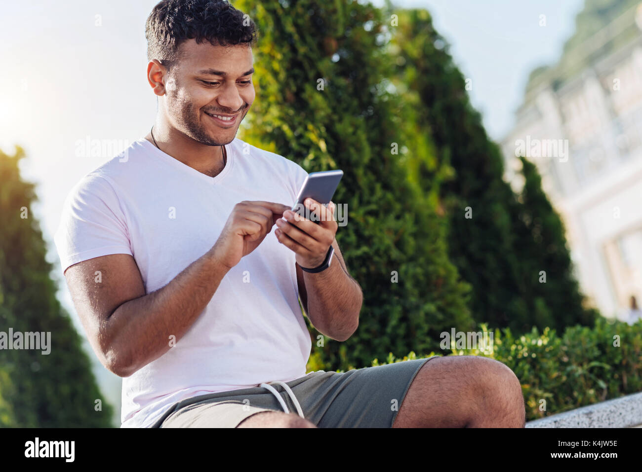 Portrait of positive student that playing with his gadget Stock Photo ...