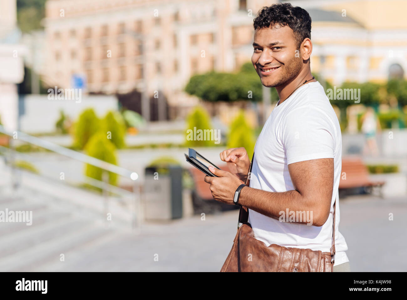 Positive delighted brunette waiting his group mates Stock Photo - Alamy