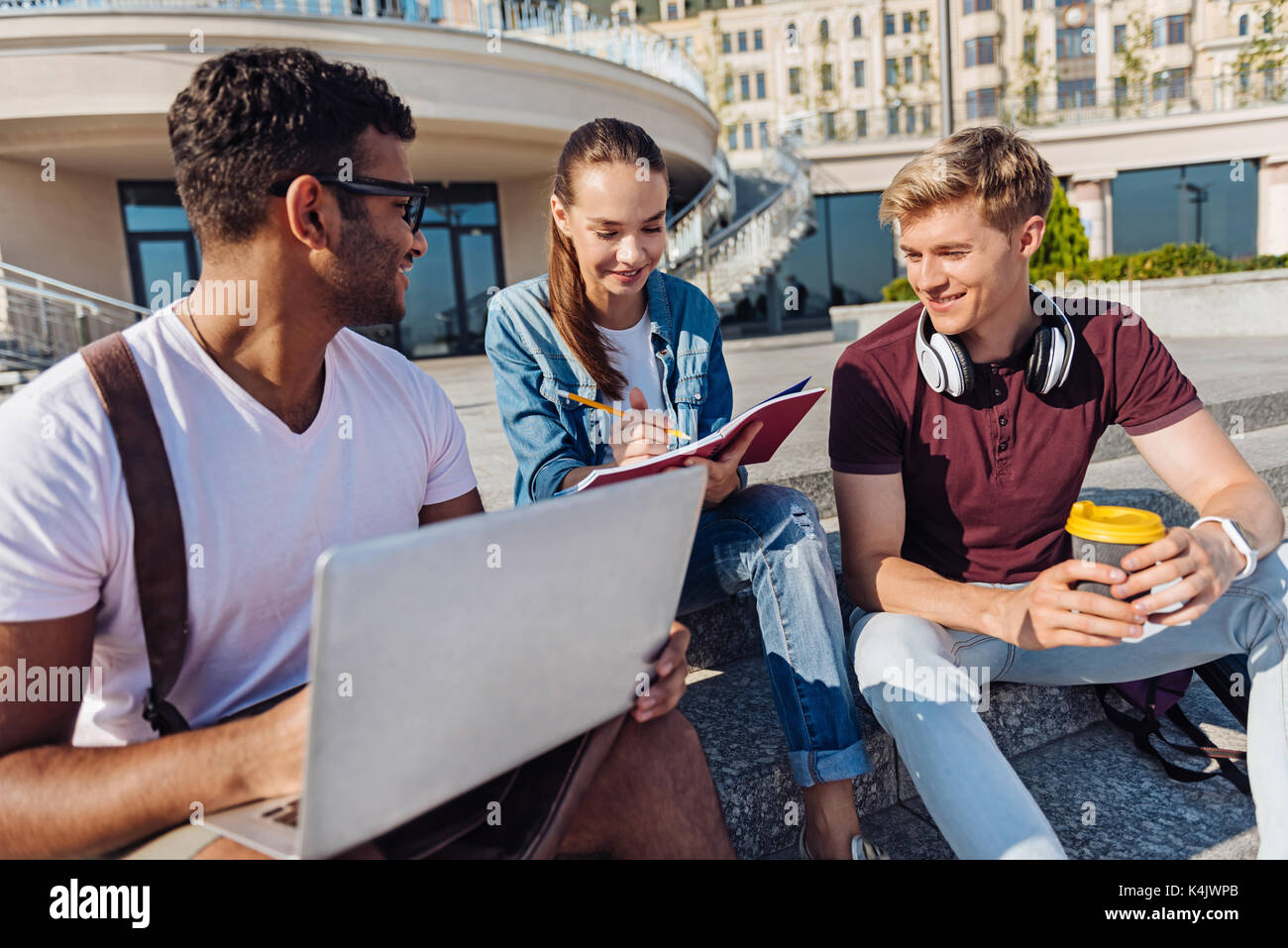 Pretty girl sitting between her group mates Stock Photo - Alamy