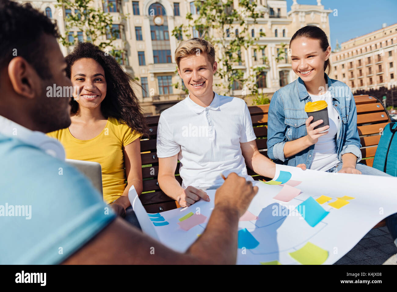 Positive friends looking at their group mate Stock Photo - Alamy