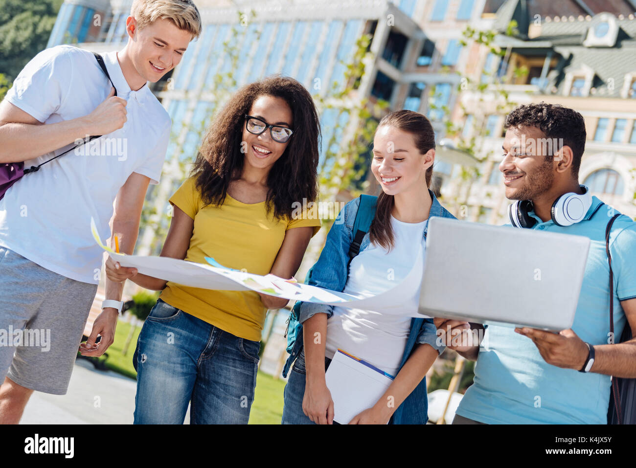 Positive friends working at their project Stock Photo - Alamy
