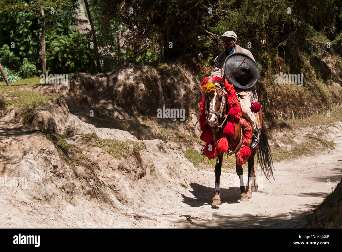A man riding a horse with traditional red and yellow Ethiopian ...