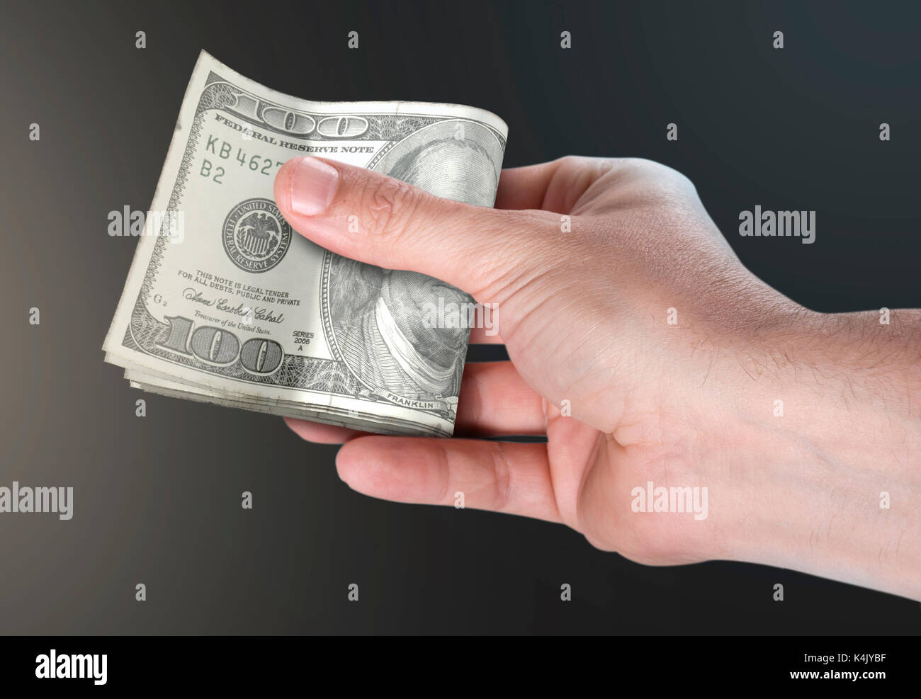 A male hand handing over a wad of folded american dollar bank notes on ...