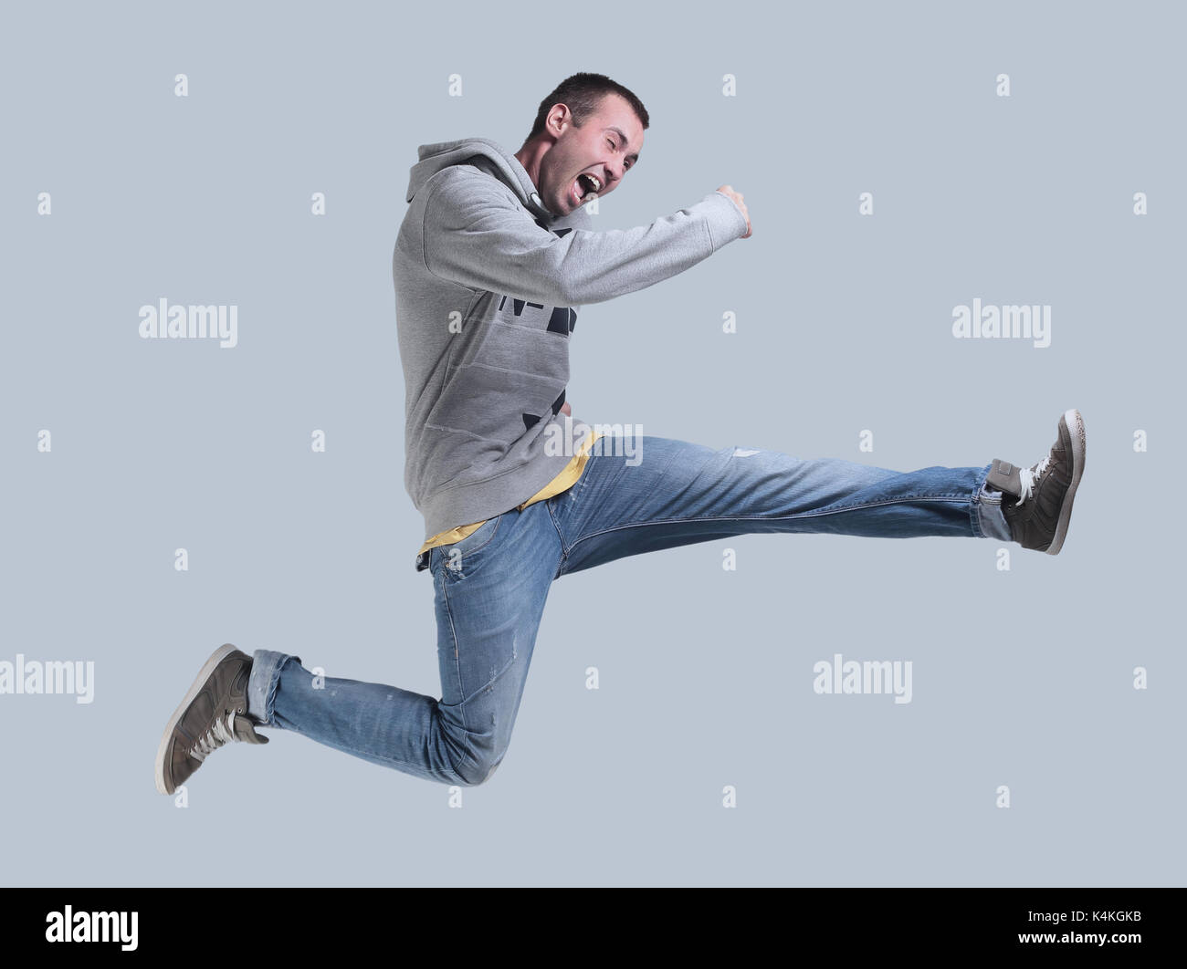 Funny cheerful happy man jumping in air over gray background Stock ...