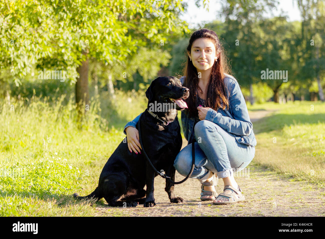 Woman walking black labrador on hi-res stock photography and images - Alamy