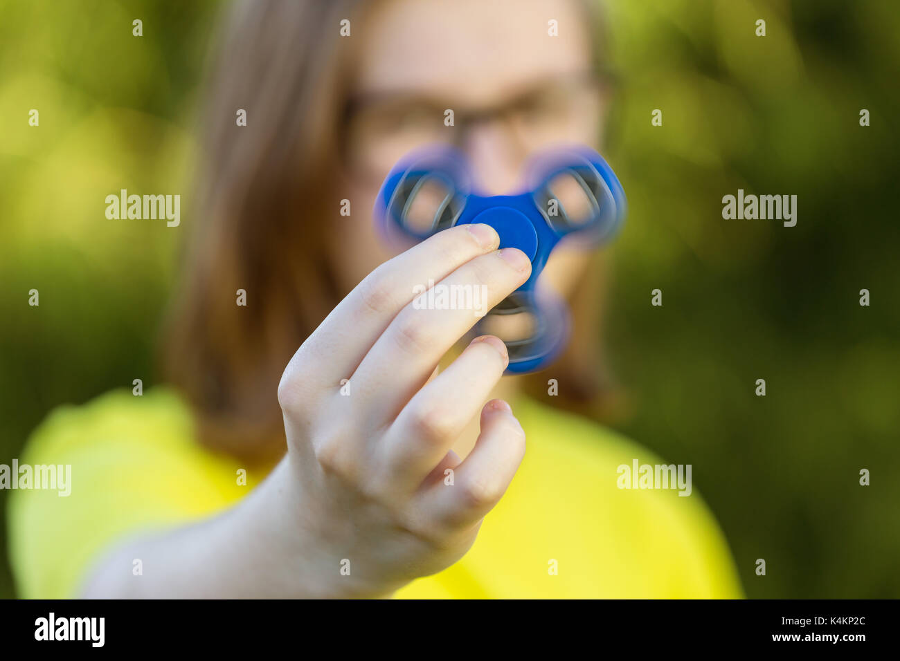 Girl's hand holding a spinning fidget spinner in her hand, spinning ...