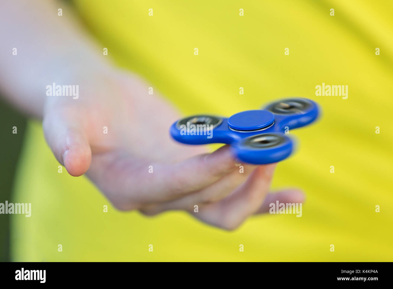Girl's hand holding a spinning fidget spinner in her hand, spinning ...