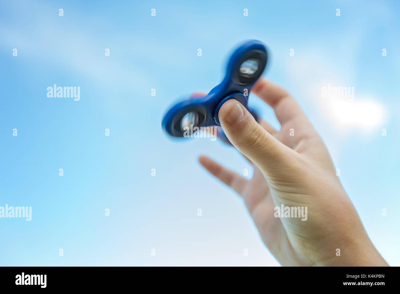 Girl's hand holding a spinning fidget spinner in her hand, spinning ...