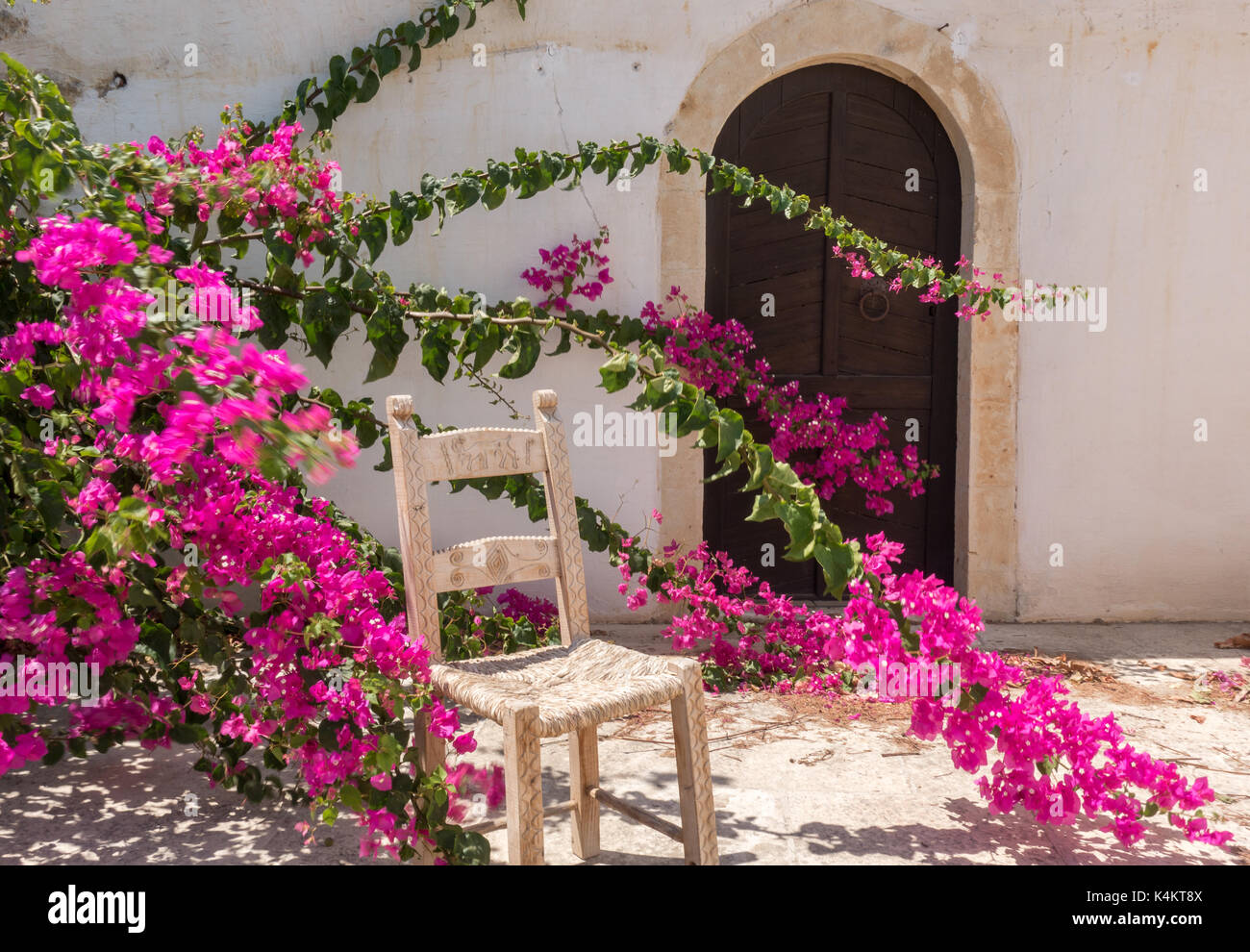 Chair by door with Bougainvillea flowers at Toplou Monastery, Lasithi ...