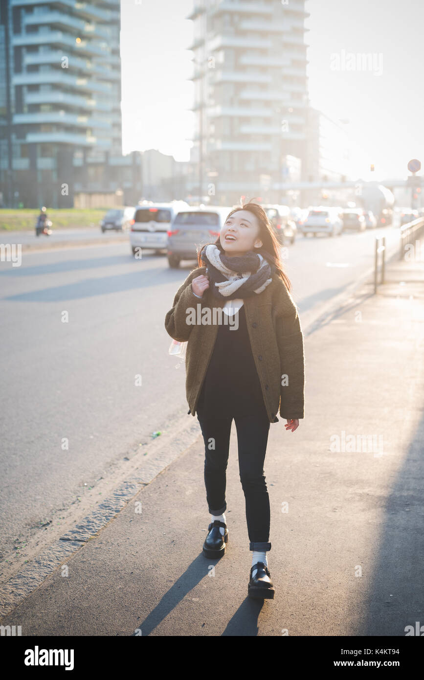 young woman walking outdoor back light looking over surprised ...