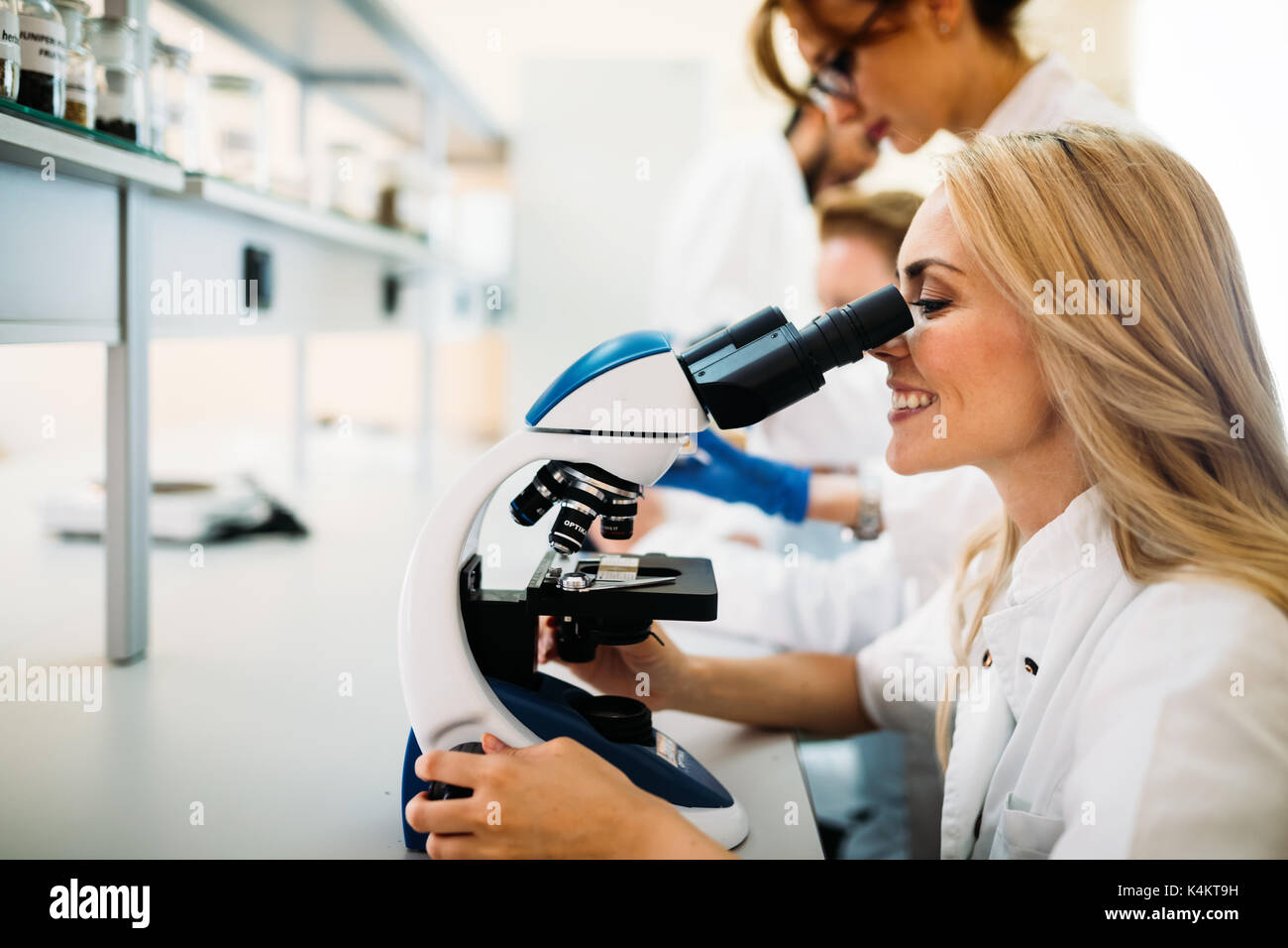 Young scientist looking through microscope in laboratory Stock Photo ...