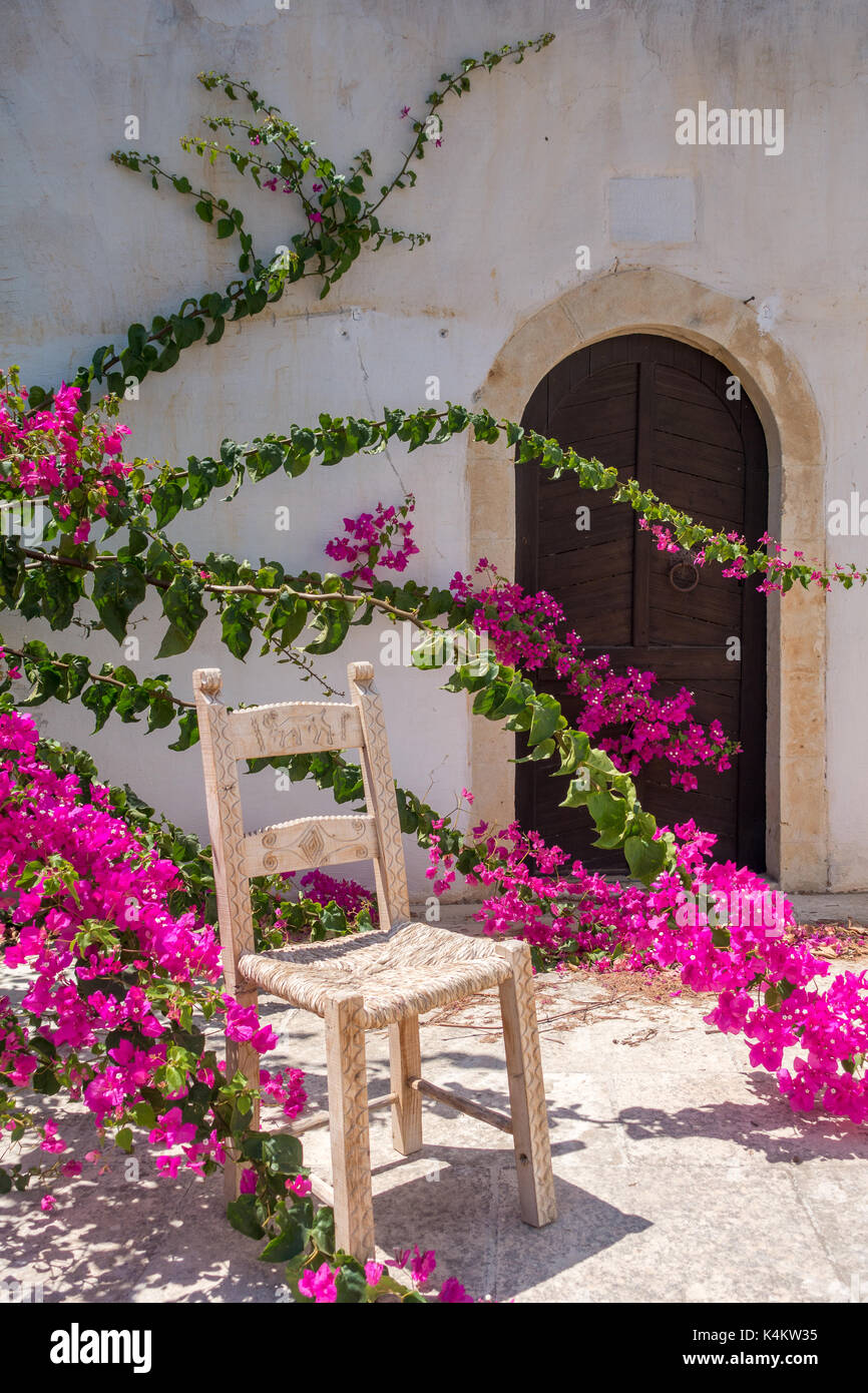 Chair by door with Bougainvillea flowers at Toplou Monastery, Lasithi ...
