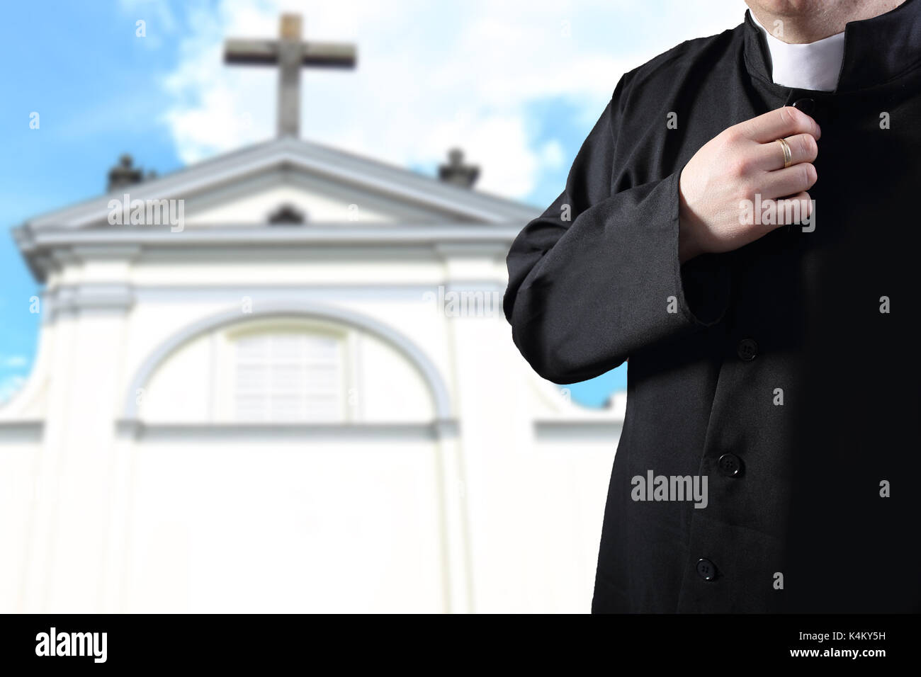 priest praying before the parish Stock Photo - Alamy