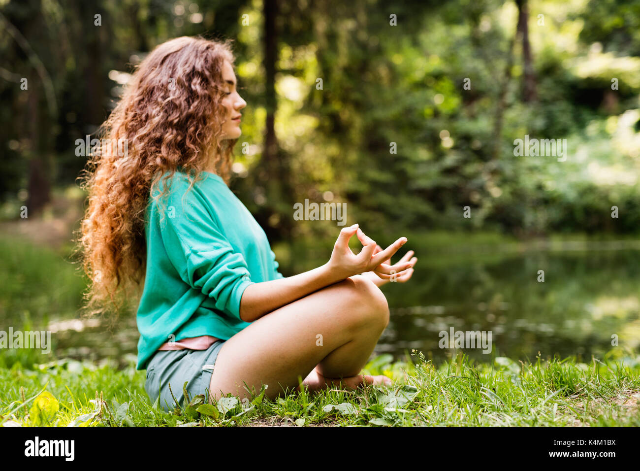 Beautiful girl practices yoga in the morning forest Stock Photo - Alamy