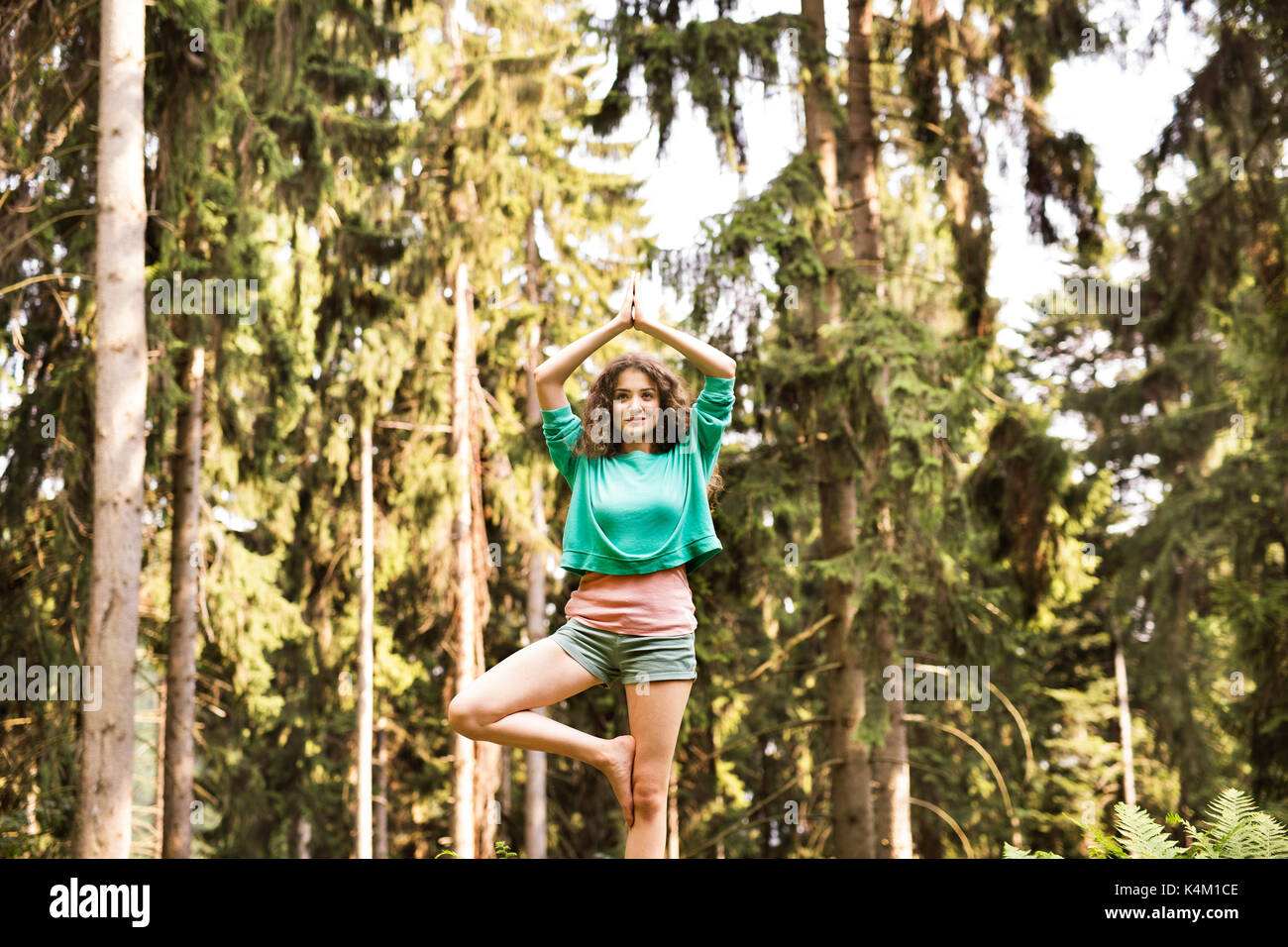 Beautiful girl practices yoga in the morning forest Stock Photo - Alamy