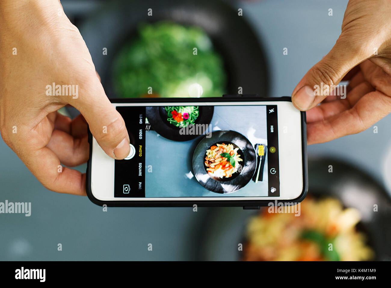 Top view of people using cellphone to take food photo in restaurant ...