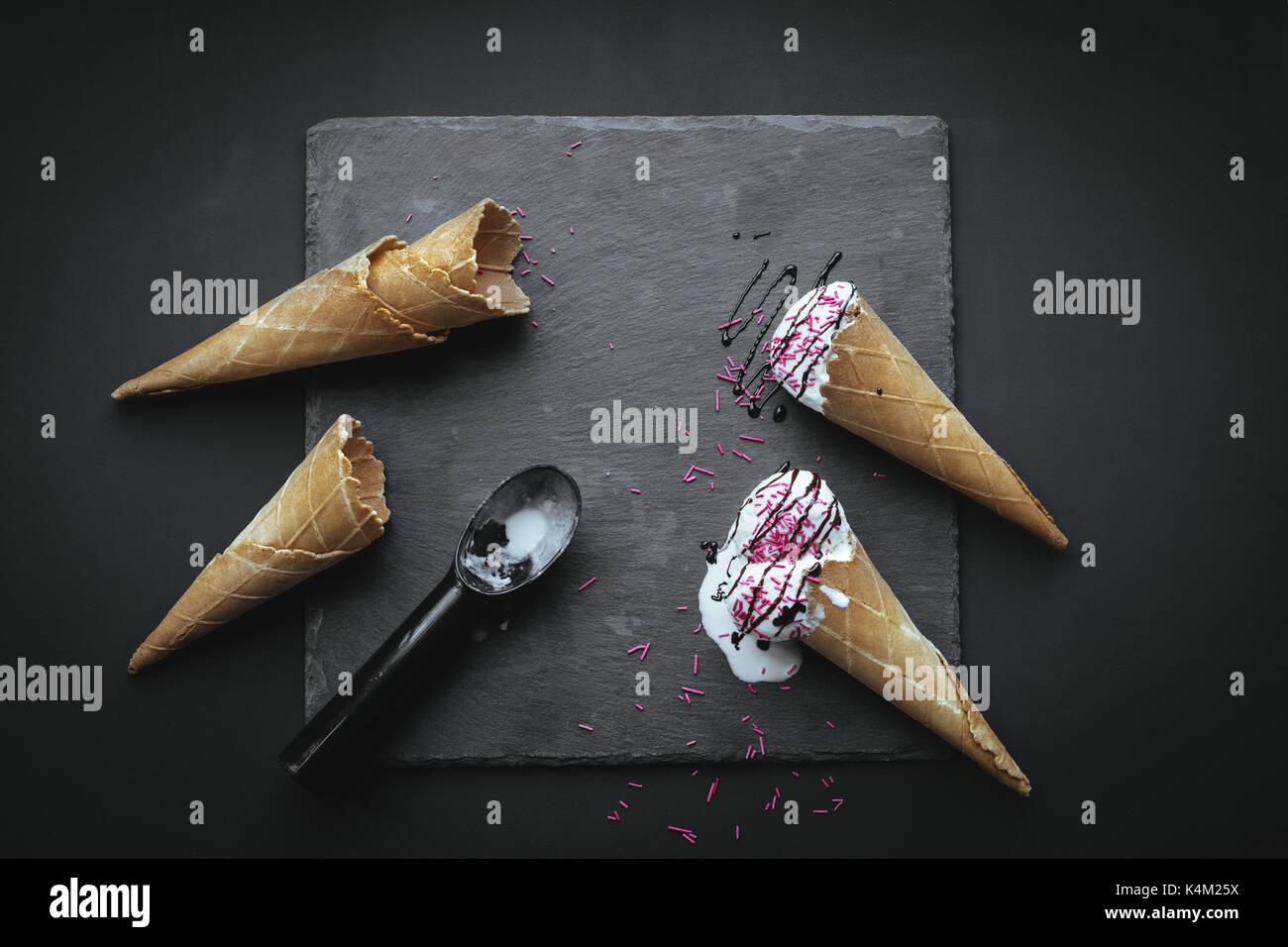 top view of homemade ice cream with sugar spreading in wafer cones on ...