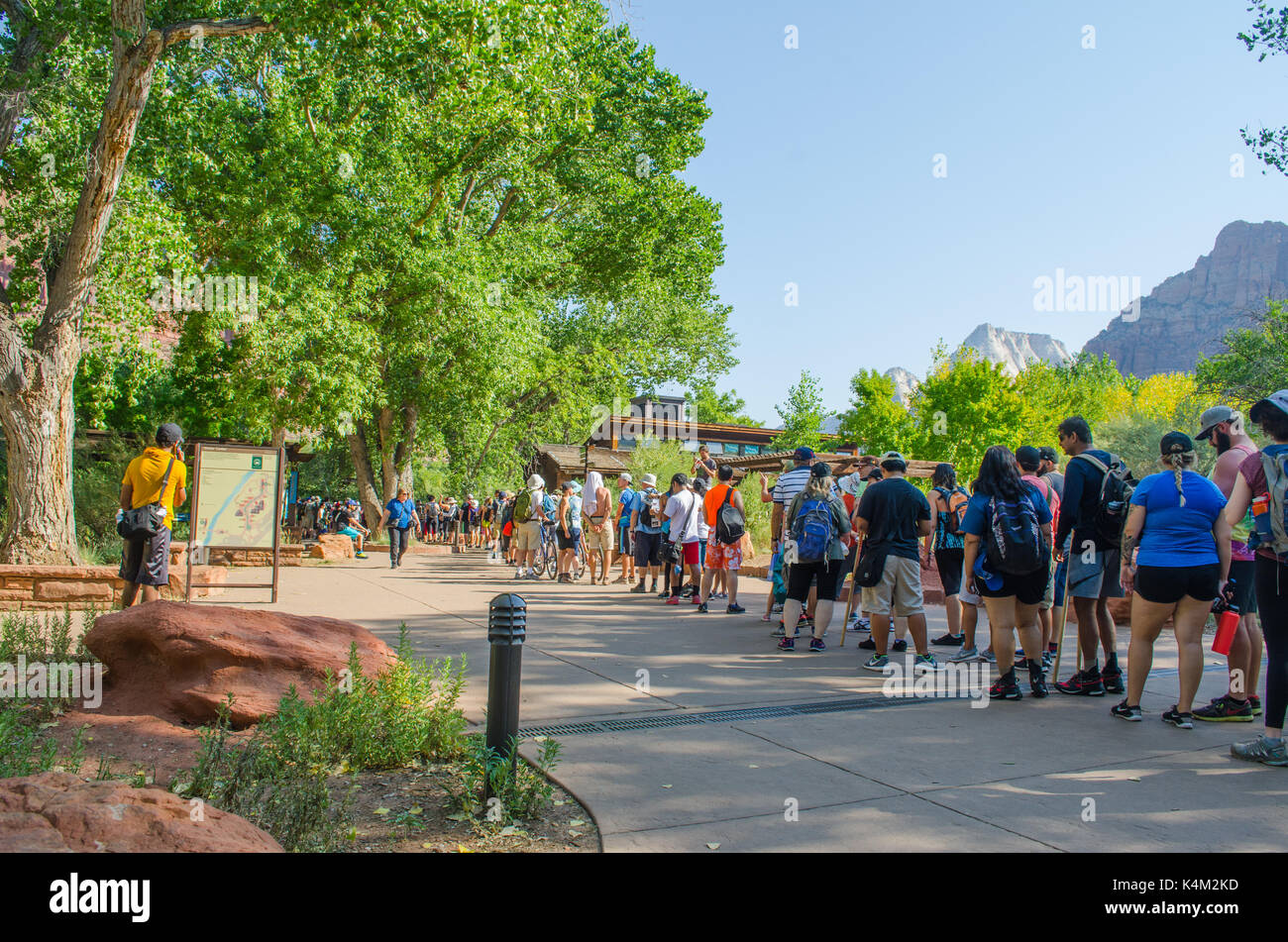 Line of visitors waiting to ride the shuttle bus at Zion National Park ...