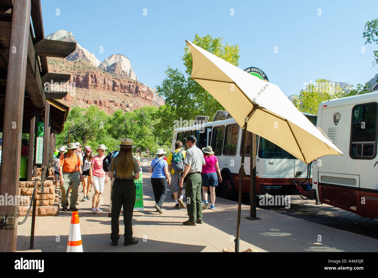 Line of visitors waiting to ride the shuttle bus at Zion National Park ...