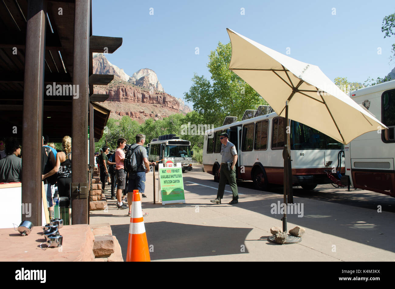Line of visitors waiting to ride the shuttle bus at Zion National Park ...