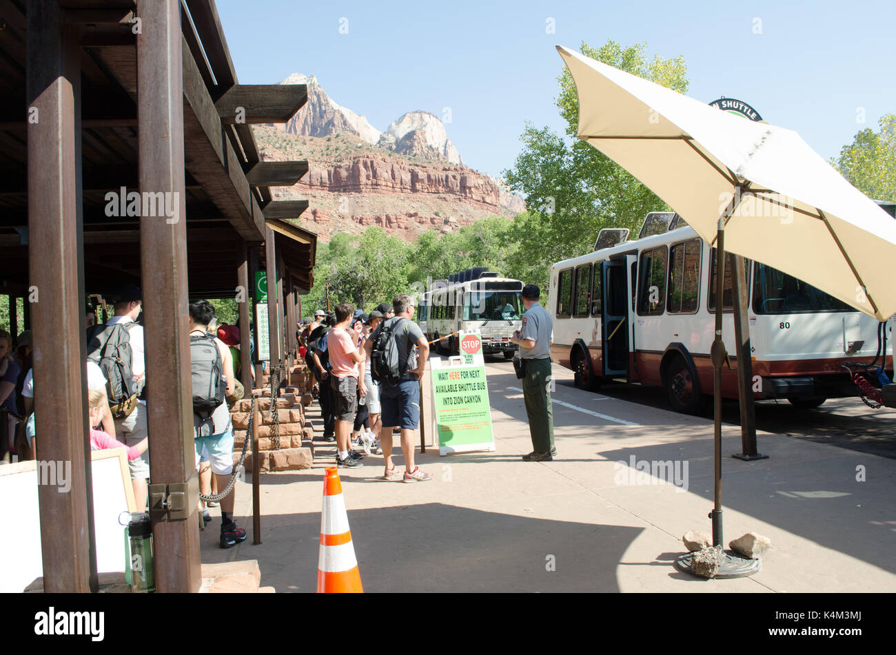 Line of visitors waiting to ride the shuttle bus at Zion National Park ...