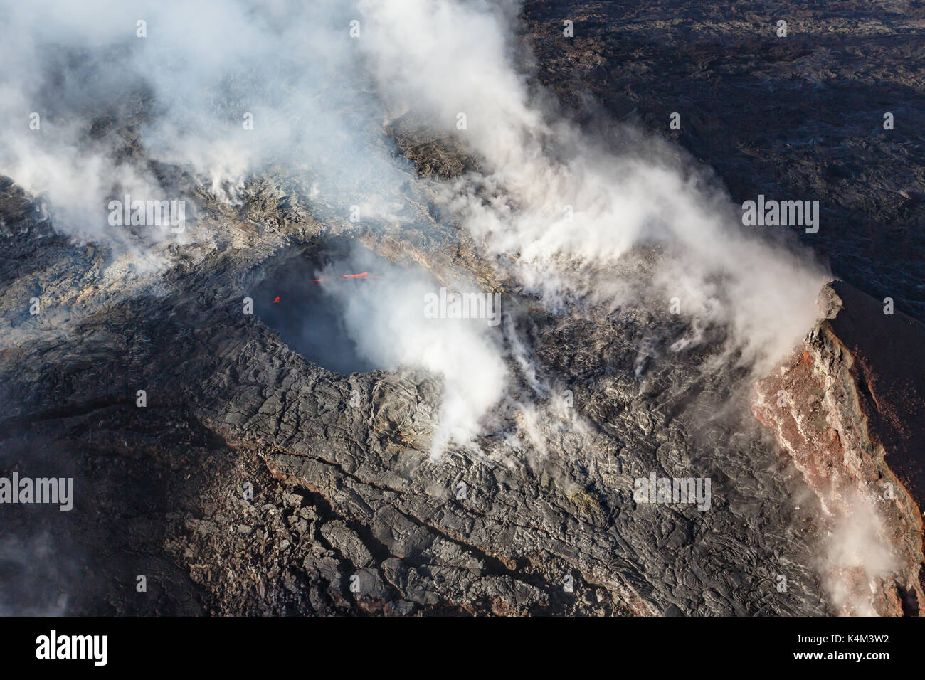 Aerial view of the smoking caldera and red molten lava of an active ...