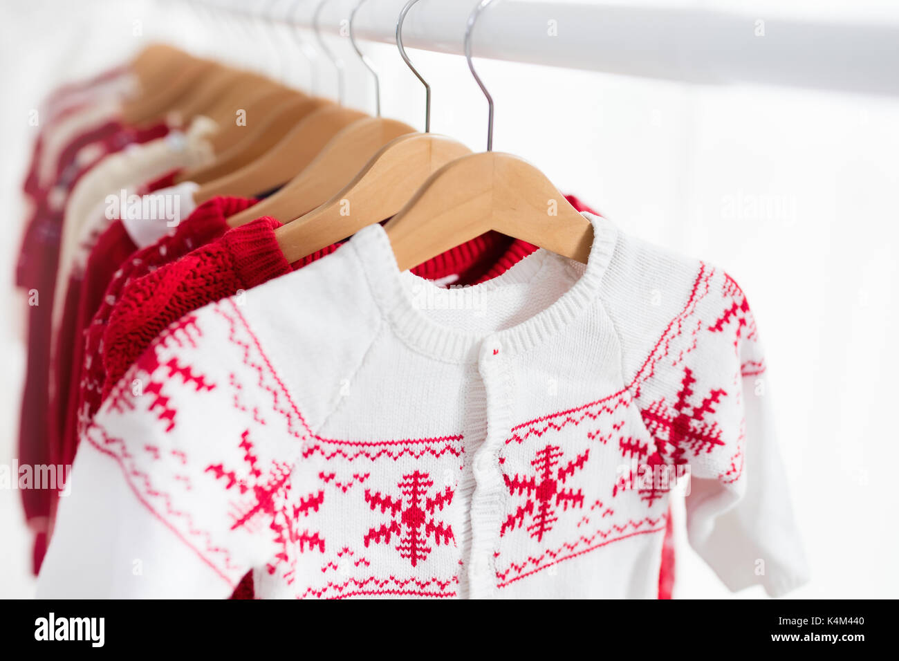 Clothes rack with red Christmas knit wear. Wardrobe with knitted winter ...