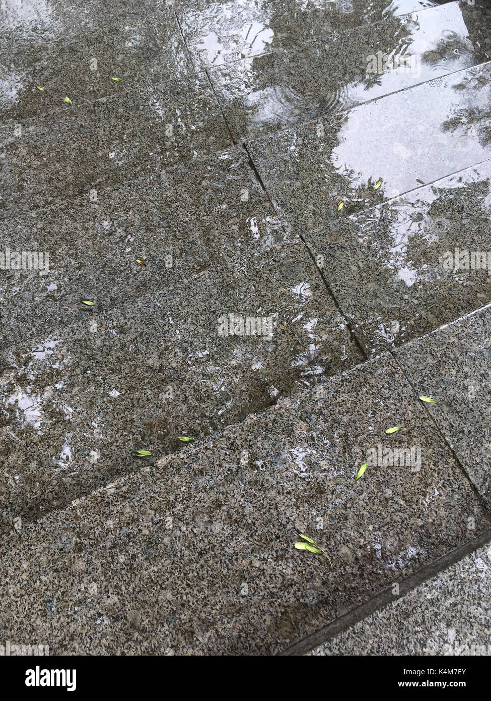 granite steps of staircase with raindrops splashes during downpour ...