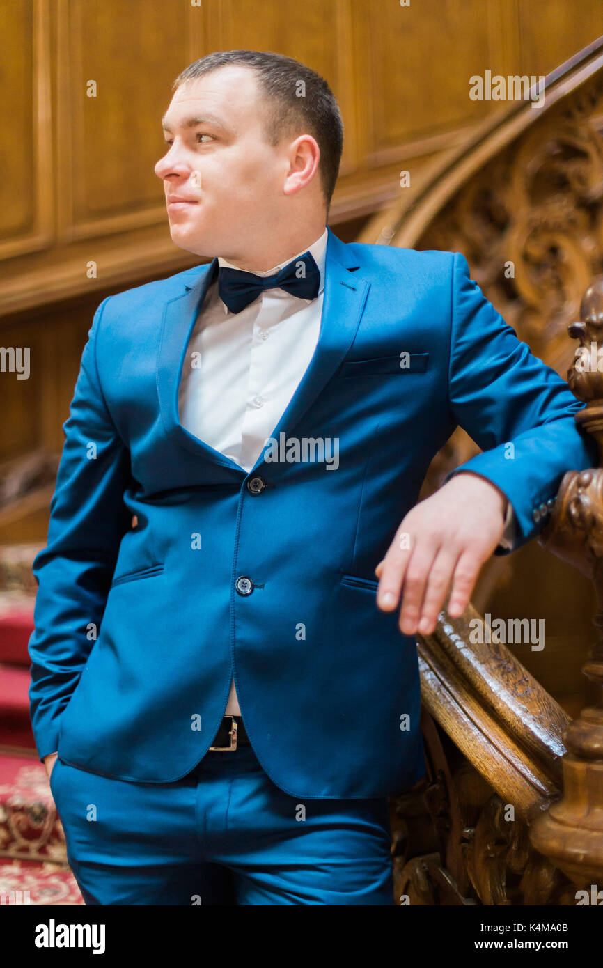 Half-length portrait of the groom looking aside while standing on the ...