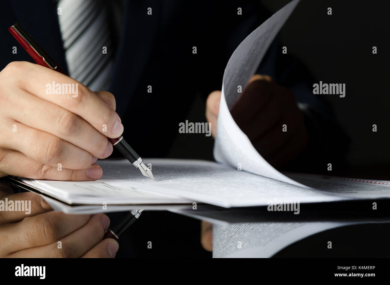 Notary signing a contract with fountain pen in dark room concept. pen ...