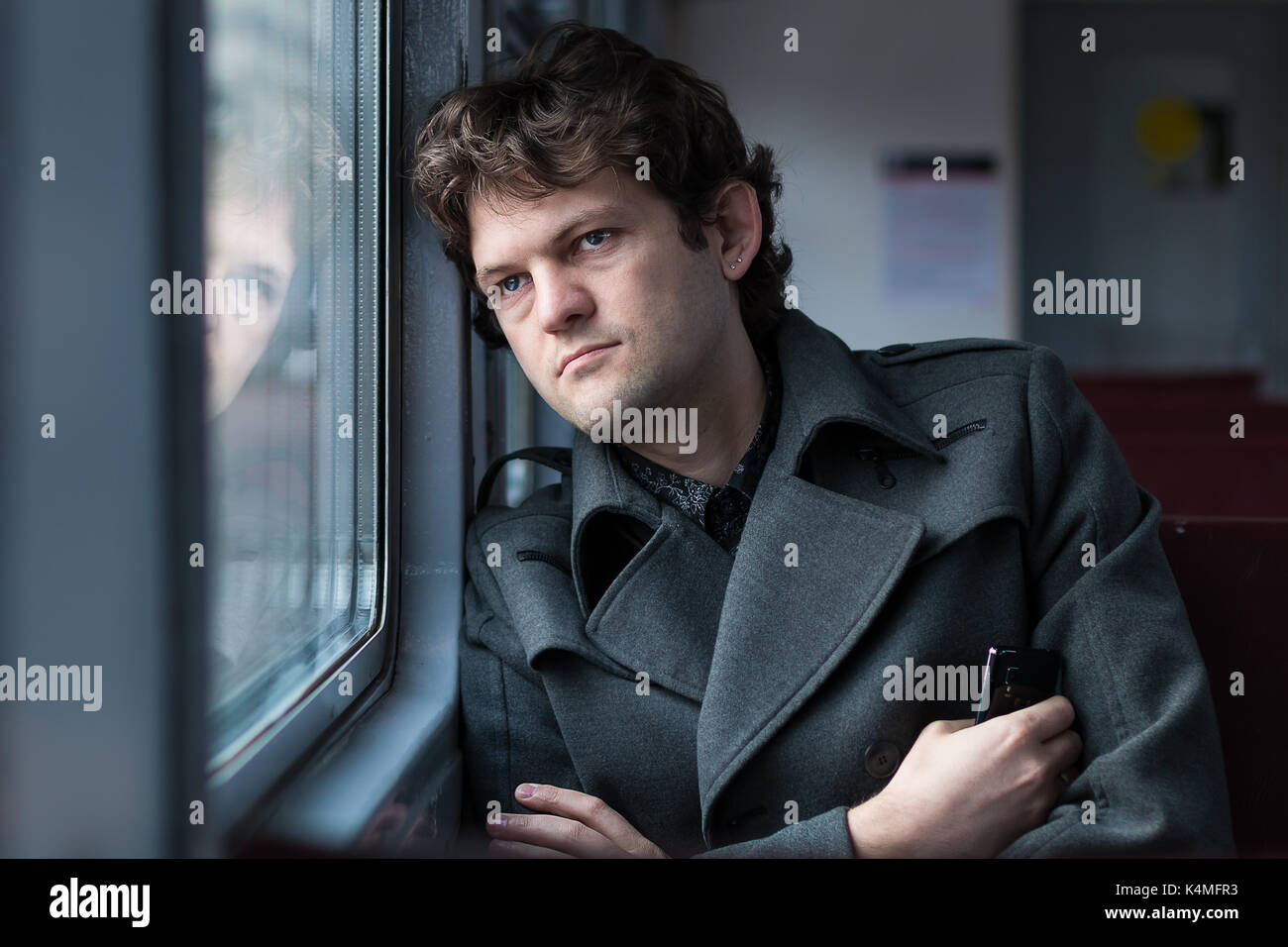 Traveling by train. Sad man traveling by train, looking through the ...