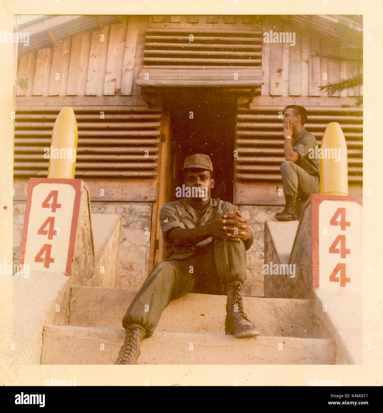 African-American soldier in uniform sitting on the stairs of a military ...