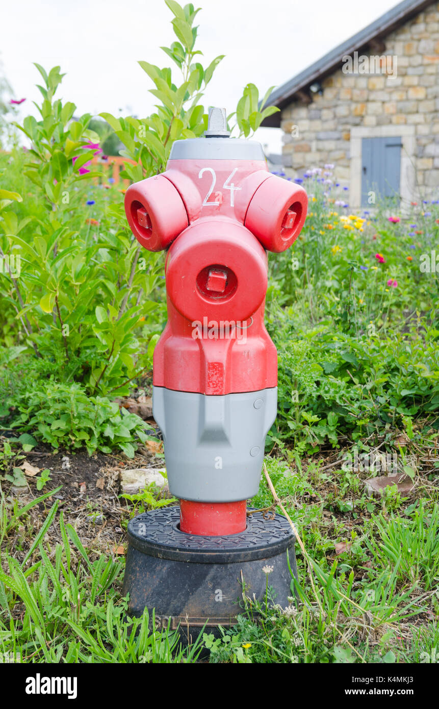Bright red roadside fire water hydrant in french town of Hardinghen ...