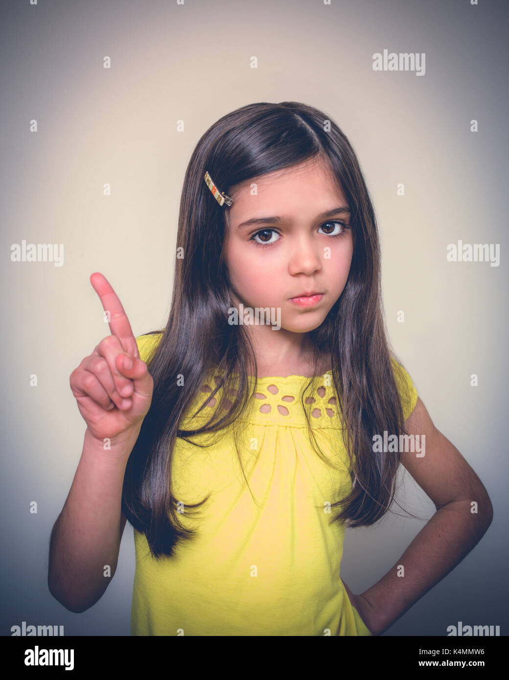 10 year old girl looking serious with finger raised in a bossy gesture ...