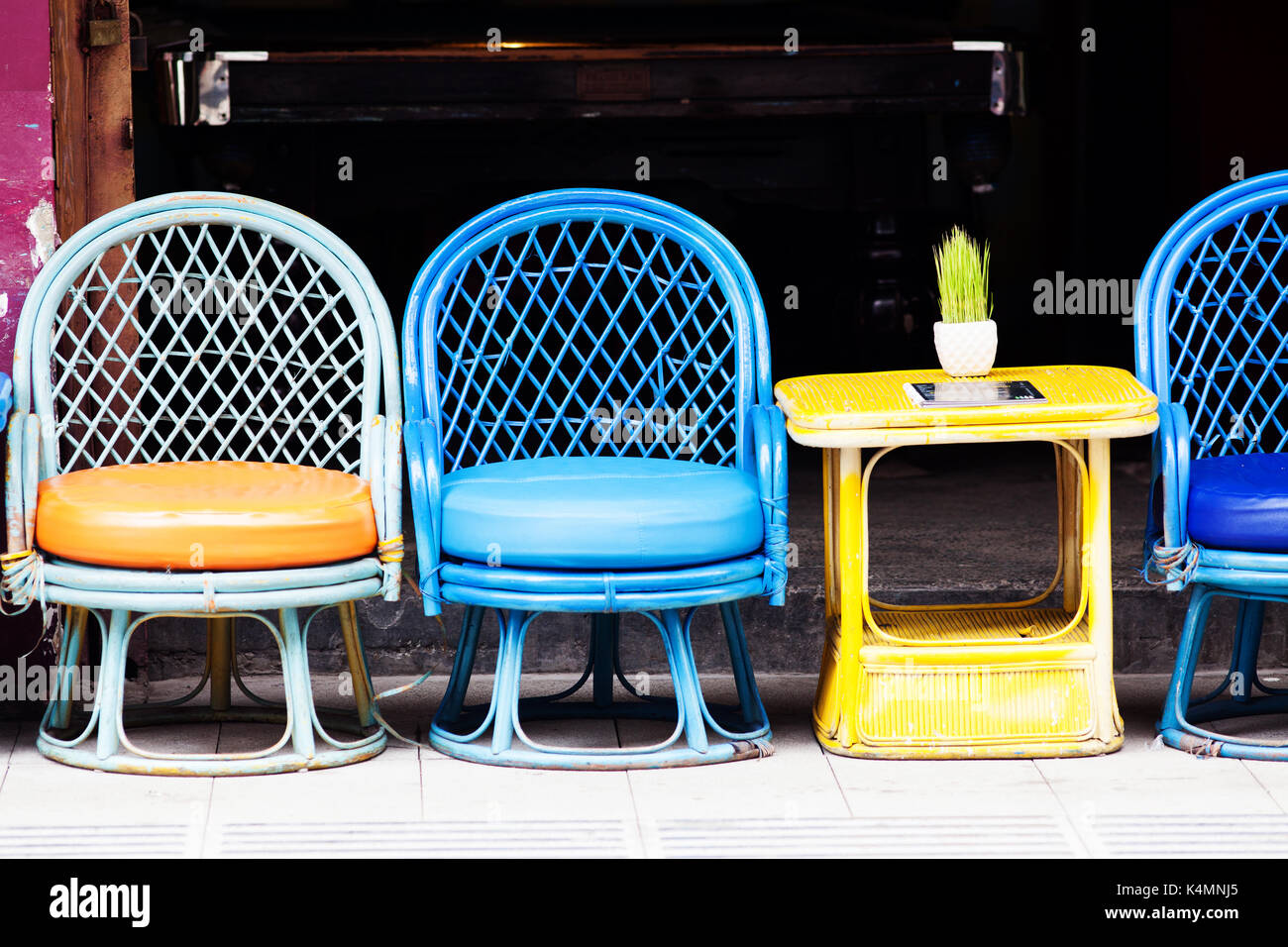 blue and yellow chairs and table outside a cafe or bar Stock Photo - Alamy