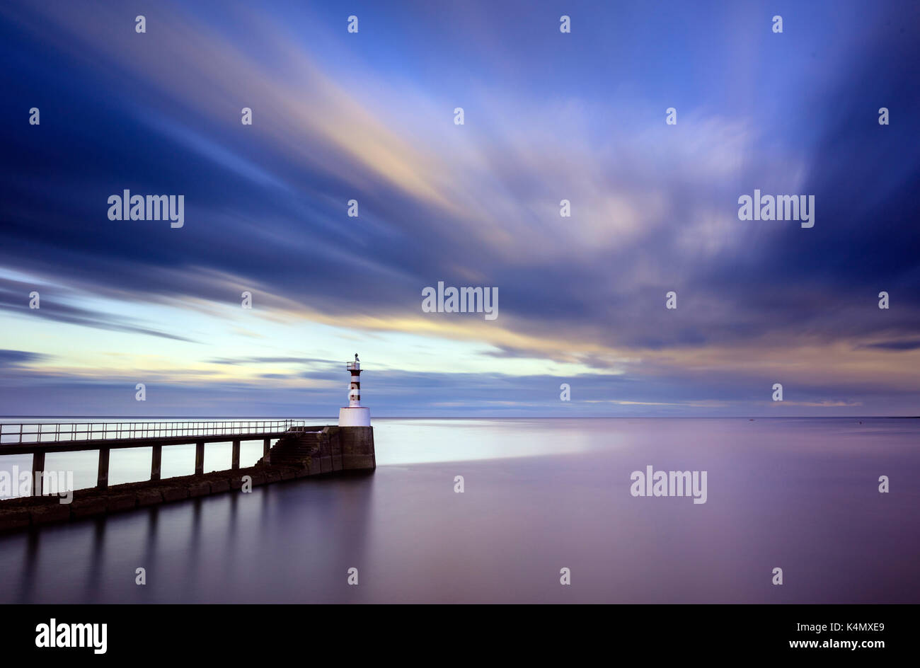 Long exposure image of Amble Lighthouse with streaky clouds and smooth ...